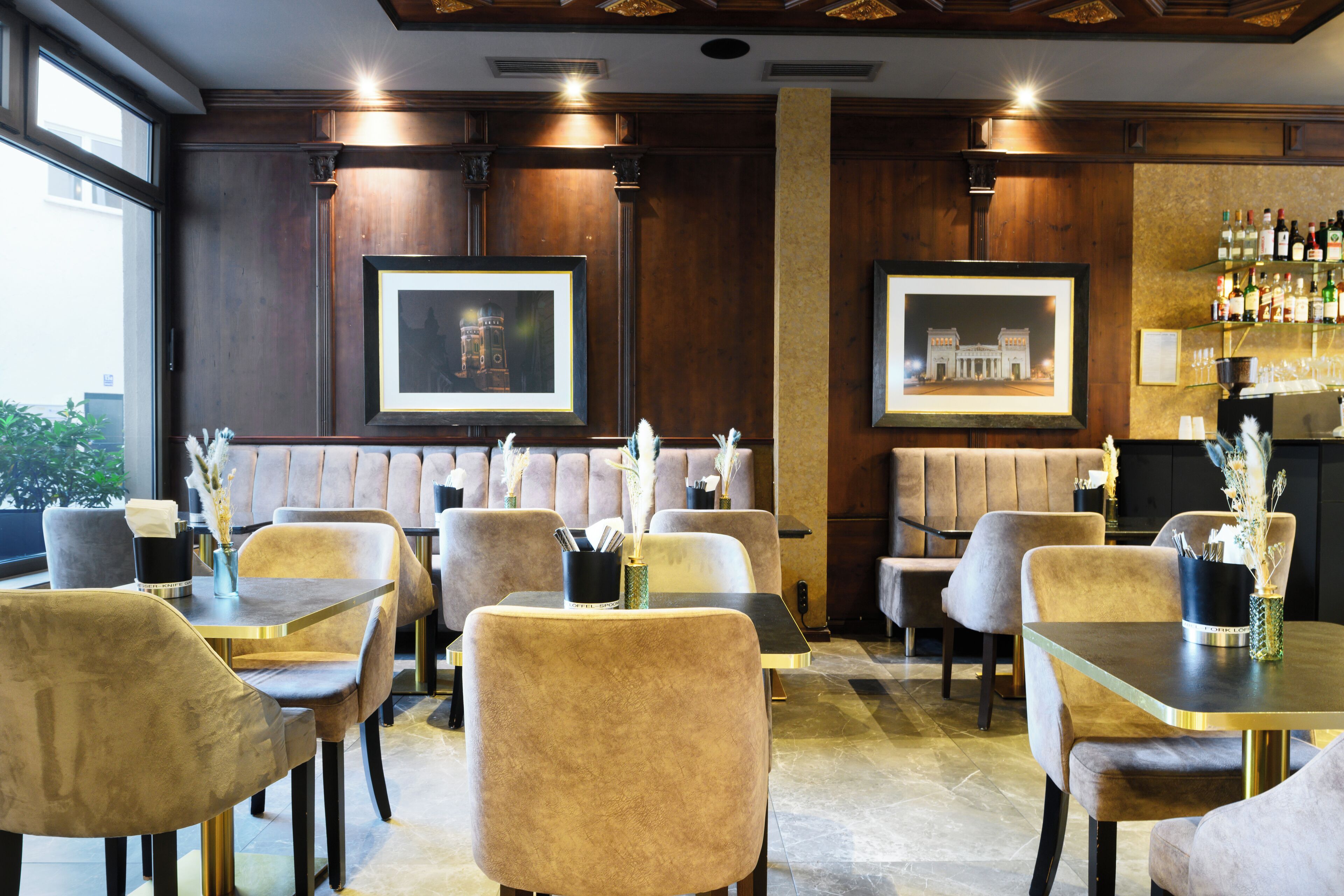 Um restaurante com cabines e mesas, quadros nas paredes e um espaço de bar com garrafas.