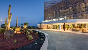 Um moderno edifício de resort com uma placa visível indicando "Barceló Lanzarote Active Resort".