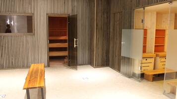 Interior moderno com um banco de madeira, uma porta de vidro e um guarda-roupa de madeira.