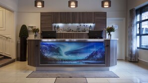Uma cozinha moderna com uma ilha grande, iluminação pendente e um mural panorâmico.