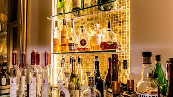 Um bar com diversas garrafas de bebidas alcoólicas, incluindo vinho e licores, expostas em prateleiras.