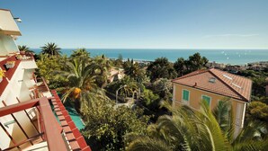 Uma vila costeira com vista para o mar, rodeada por vegetação exuberante e palmeiras.