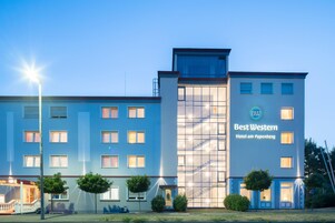 Um edifício de hotel com vários andares, janelas amplas e uma placa indicando ser o Best Western Hotel am Papenberg.