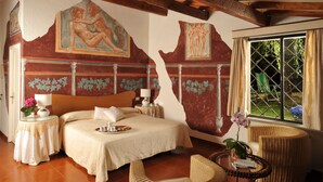 Quarto com cama, duas mesas de cabeceira, janela com cortinas e um mural na parede.