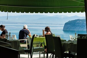 Mesa posta para refeição com vista para um lago e montanhas.