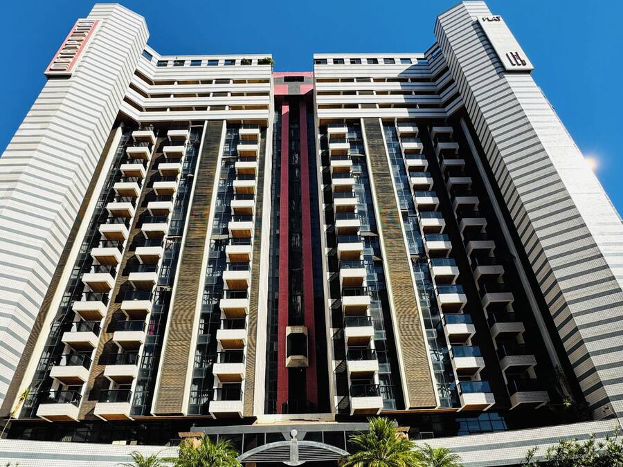Um edifício alto com várias varandas e um elemento vertical central.