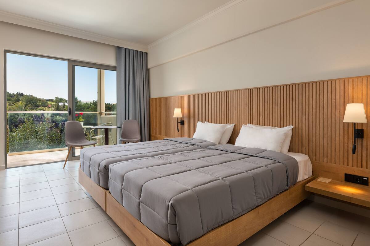 Quarto de hotel moderno com uma cama grande, uma escrivaninha e uma cadeira.