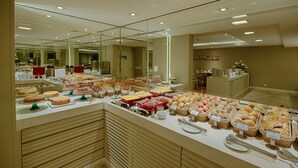 Buffet com diversos alimentos e um espelho refletindo o ambiente.