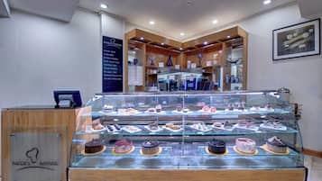Vitrine de pastelaria com vários bolos e pastelaria.