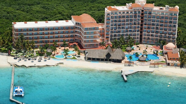 Resort com vários edifícios de hotel, praia e área de piscina.