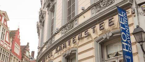 Um edifício histórico com detalhes arquitetônicos elaborados, incluindo uma placa de destaque para 'The Gravensteen Hotel'.