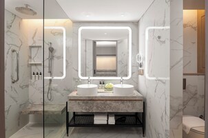 Uma casa de banho moderna com duas pias, um espelho grande e zona de duche.