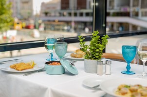 Uma mesa de jantar com pratos de comida, copos e uma pequena planta.