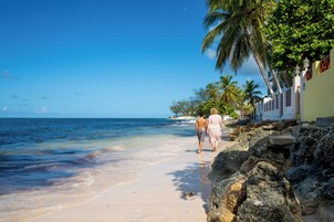 Perto da praia, areia branca, espreguiçadeiras, guarda-sóis