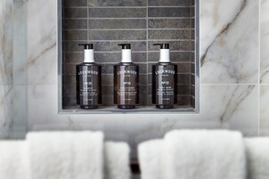 Três produtos de higiene Lockwood New York numa prateleira de casa de banho.