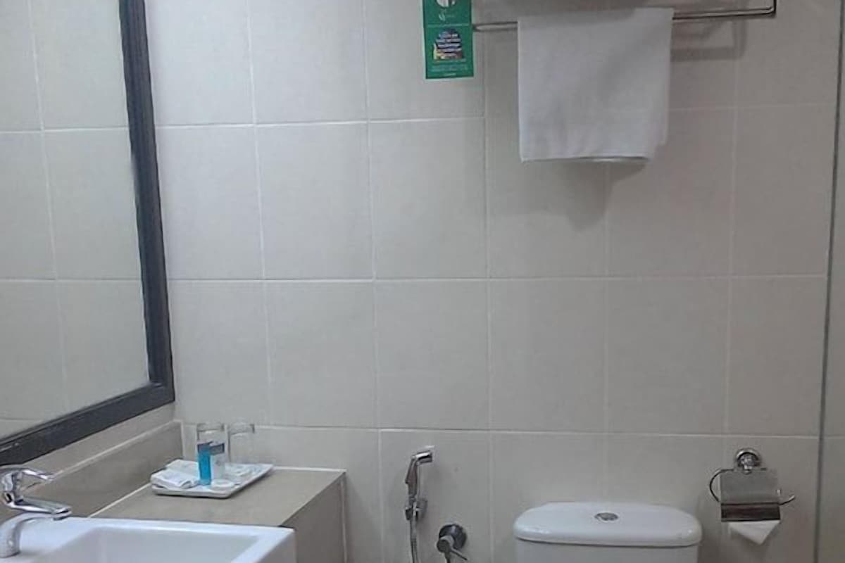 Casa de banho com lavatório, sanita e chuveiro.