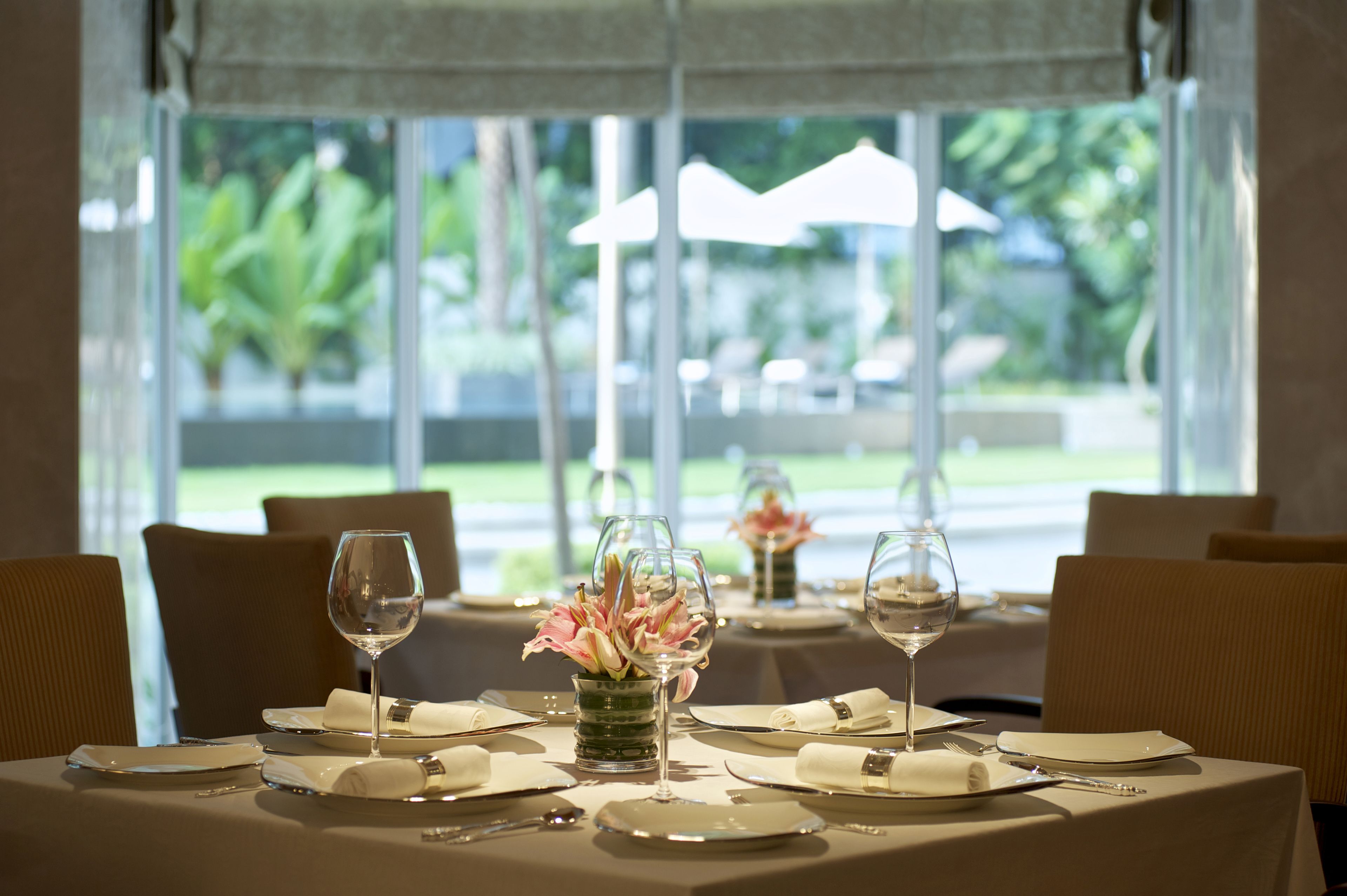 Mesa de jantar posta para refeição com vista para o exterior.