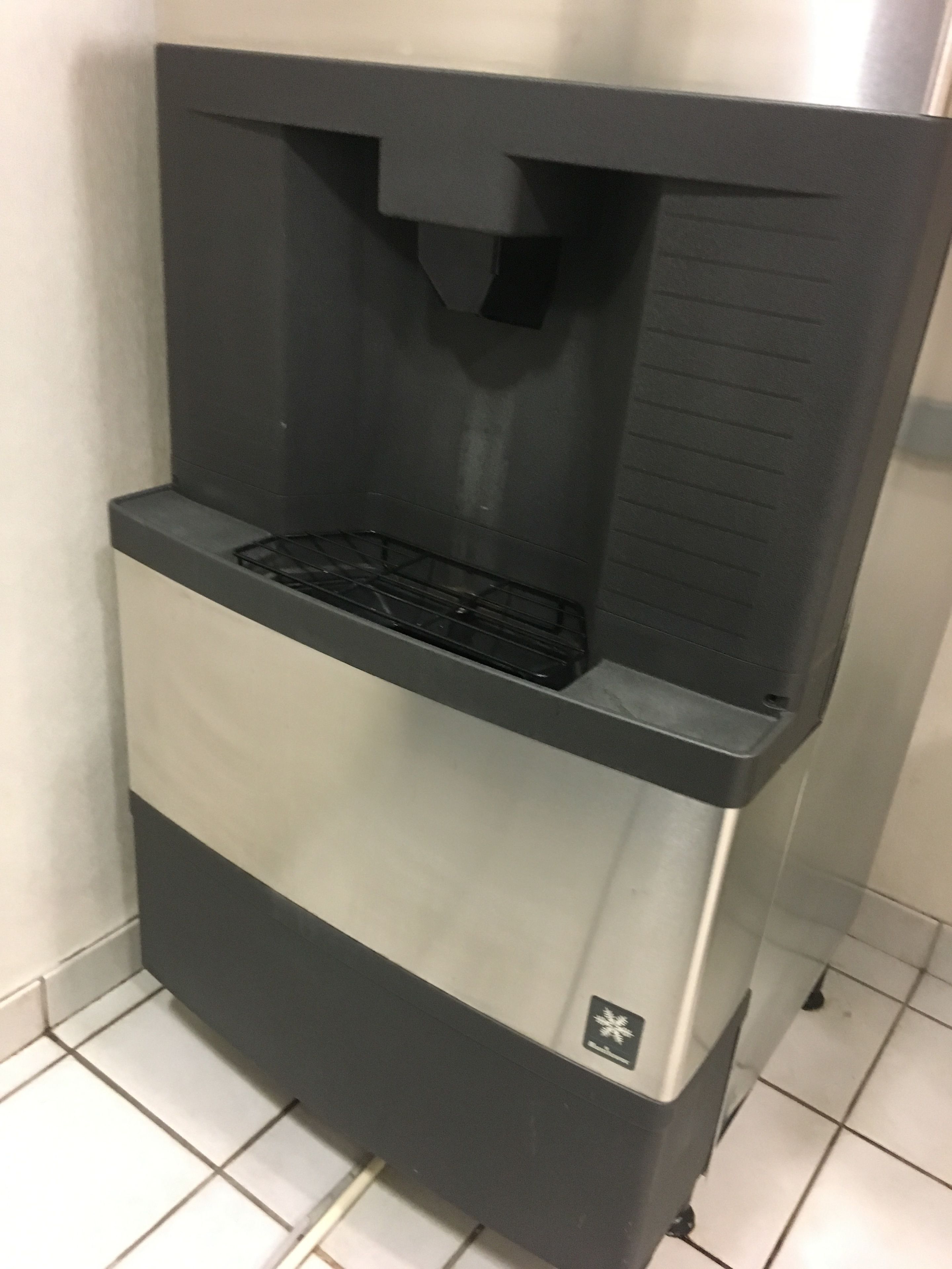 Uma cozinha moderna com geladeira de aço inoxidável e máquina de café embutida.