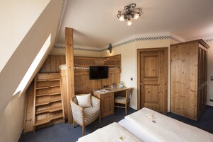 Quarto com mezanino para dormir, escrivaninha com cadeira, televisão e armários de madeira.