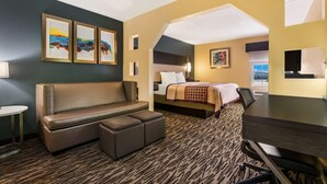 Quarto de hotel com sofá, cama, escrivaninha e vista para o exterior.