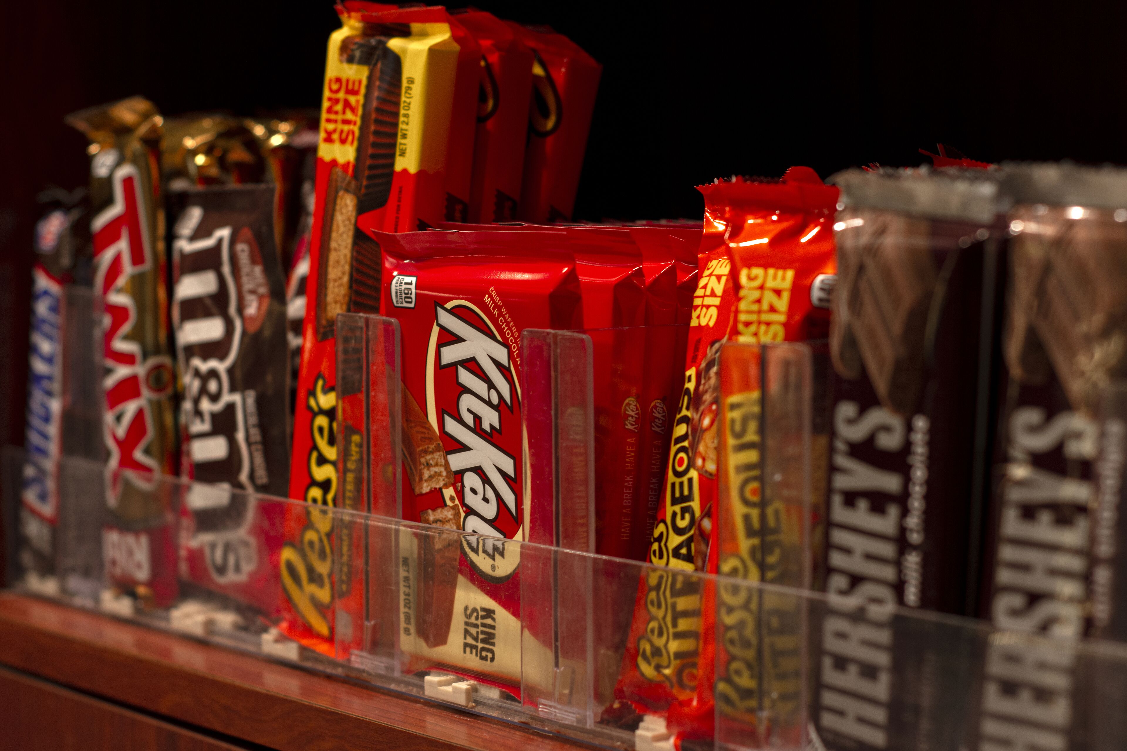 Diversas barras de chocolate expostas em uma vitrine de vidro.