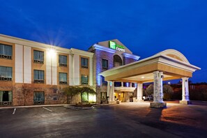 Um hotel Holiday Inn Express com entrada coberta e estacionamento.