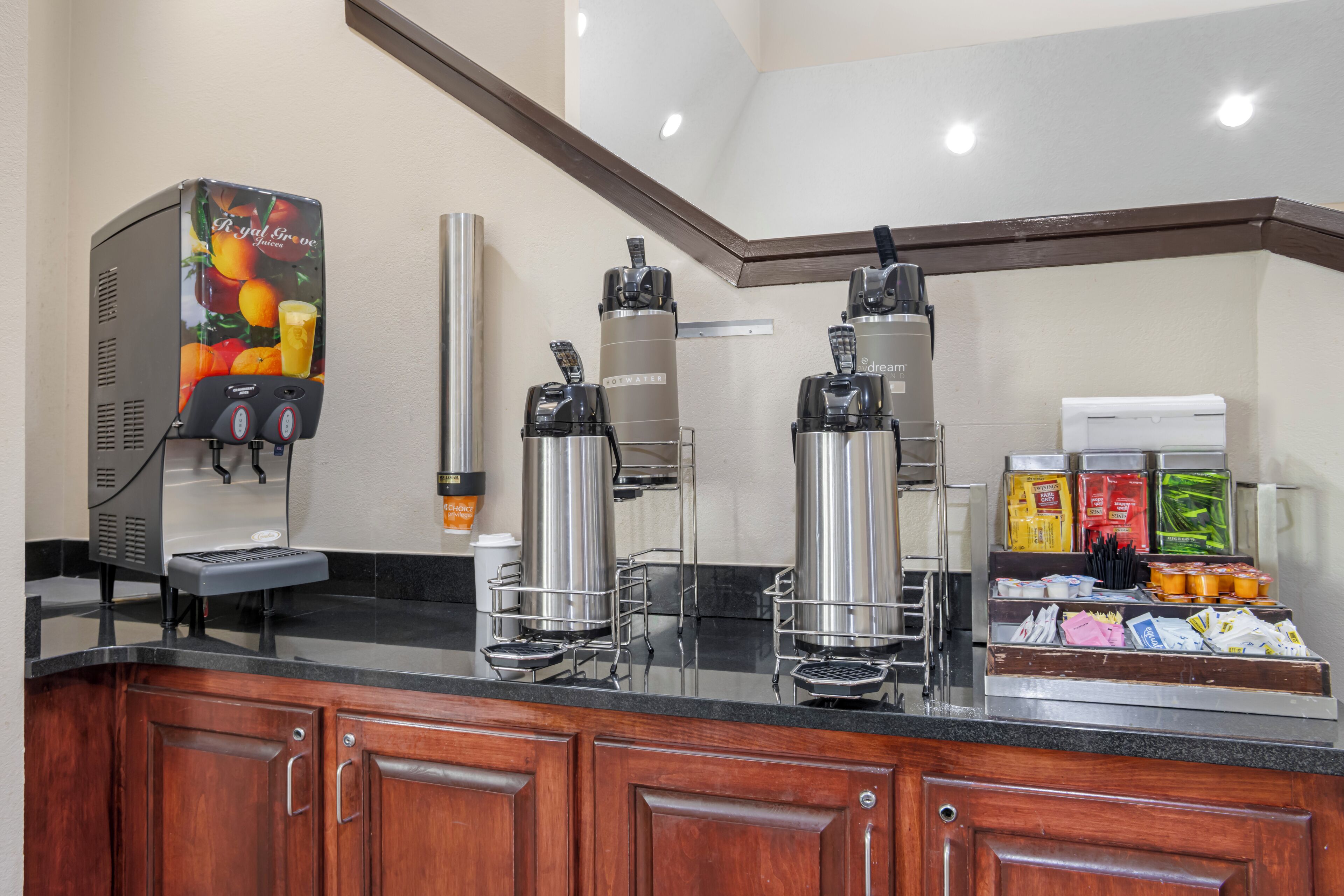 Uma estação de café com várias máquinas de café e um dispensador de bebidas.