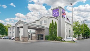 Edifício Sleep Inn & Suites by Choice Hotels, com estacionamento e céu claro.