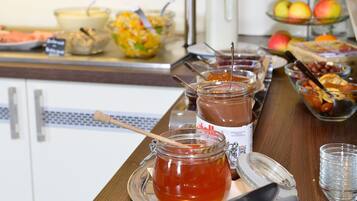 Uma mesa de buffet com diversos alimentos e acompanhamentos.
