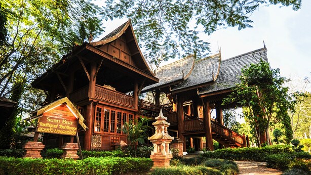 Um edifício tradicional tailandês com uma placa indicando 'Suan Bua Traditional Thai Massage'.