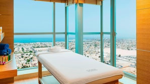 Quarto com cama, vista para a cidade e uma grande janela.