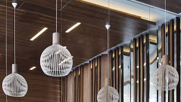 Interior moderno com painéis de madeira e luminárias esféricas penduradas.