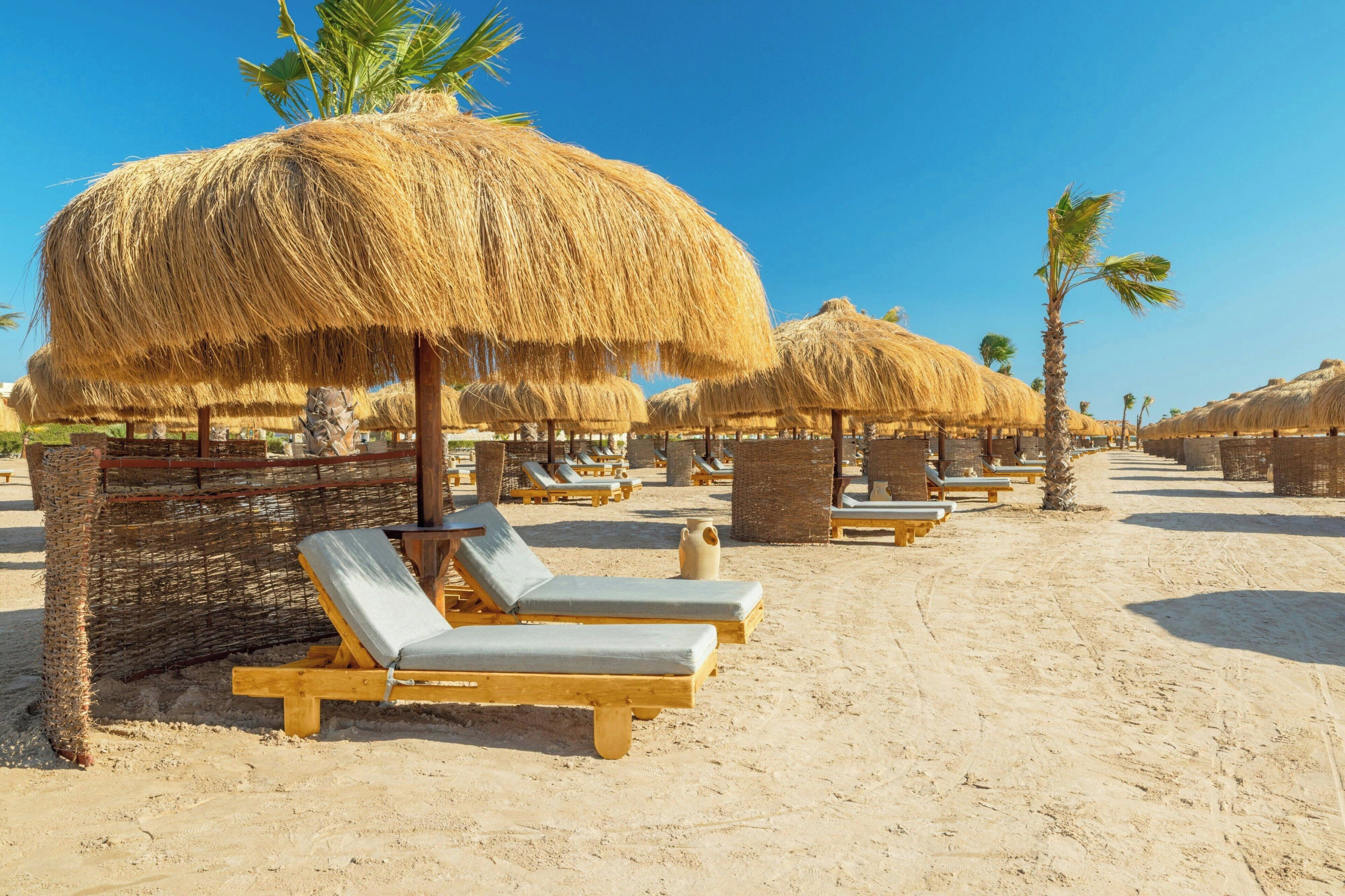 Uma praia privada, espreguiçadeiras, guarda-sóis de praia 