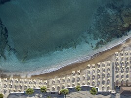 Na praia, espreguiçadeiras, guarda-sóis, toalhas de praia