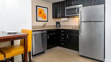 Um frigorífico/congelador grande, um micro-ondas, uma placa de cozinha