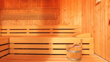Uma sauna de madeira com bancos e um balde de madeira.