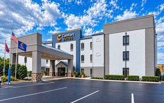 Hotel com placa indicando 'Comfort Suites' e entrada coberta.
