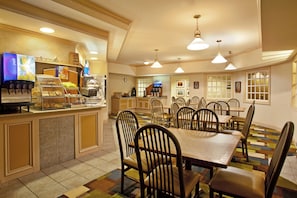 Um restaurante com área de refeições central, um balcão de comida e um bar.