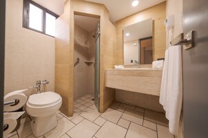 Uma casa de banho moderna com sanita, lavatório e chuveiro.