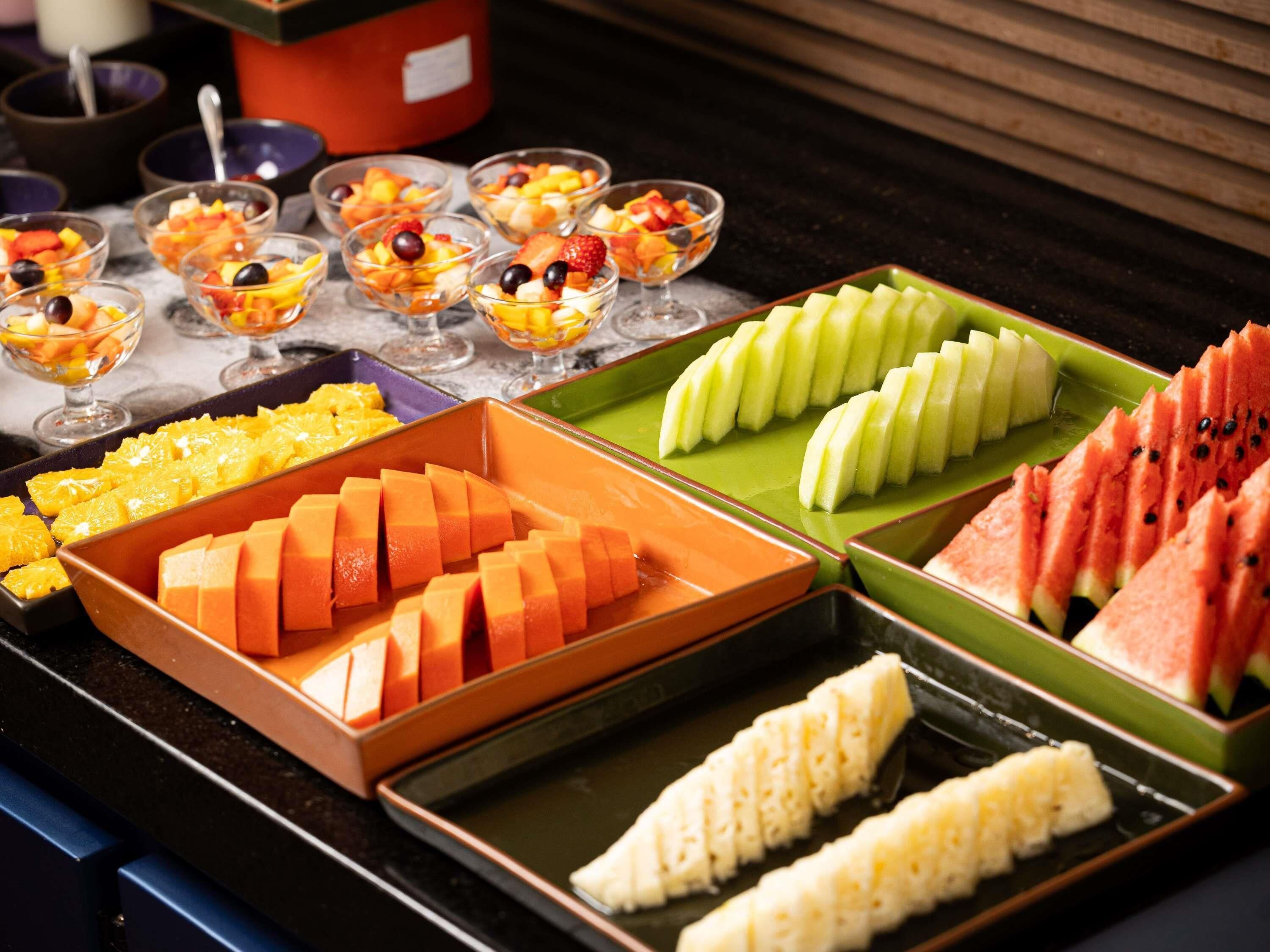 Buffet com diversas frutas e sobremesas.