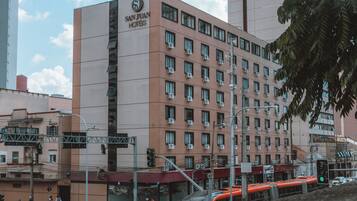 Um hotel de vários andares com uma placa de destaque que diz "San Juan Hotels".