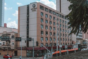 Um hotel de vários andares com uma placa de destaque que diz "San Juan Hotels".