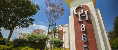 Entrada de hotel com uma placa de destaque exibindo o nome e o endereço.