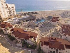 Resort com vários edifícios, piscina e praia.