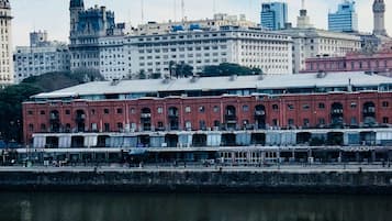Um edifício à beira-mar com vários andares, destacando-se pela fachada vermelha e telhado plano.
