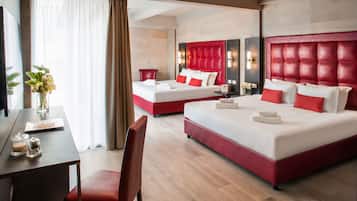 Quarto de hotel com duas camas, uma escrivaninha e uma cadeira.
