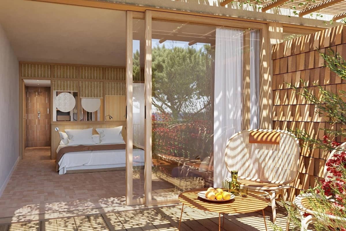 Um quarto com uma cama, uma mesinha com frutas e uma cadeira.