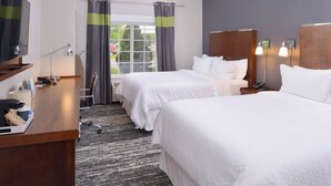 Quarto de hotel com duas camas, uma escrivaninha com telefone e uma televisão.