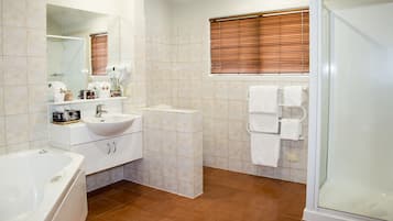 Casa de banho com banheira, lavatório e chuveiro.