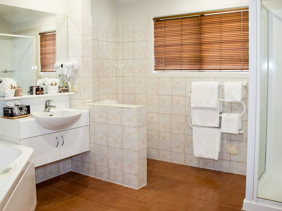 Casa de banho com banheira, lavatório e chuveiro.